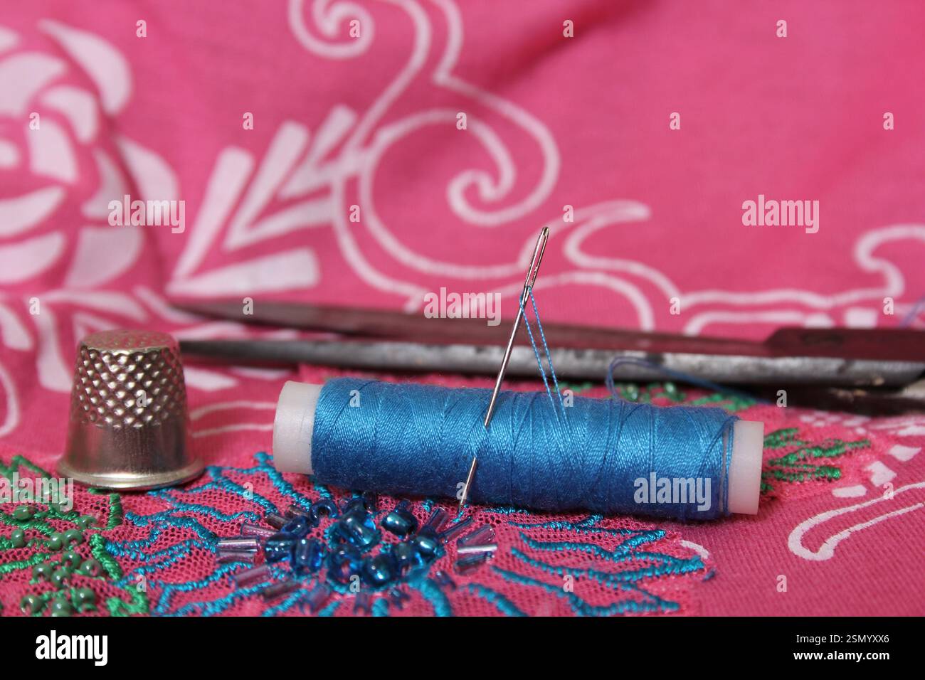 Spool of Blue Thread on Vintage Beaded Fabric Stock Photo - Alamy