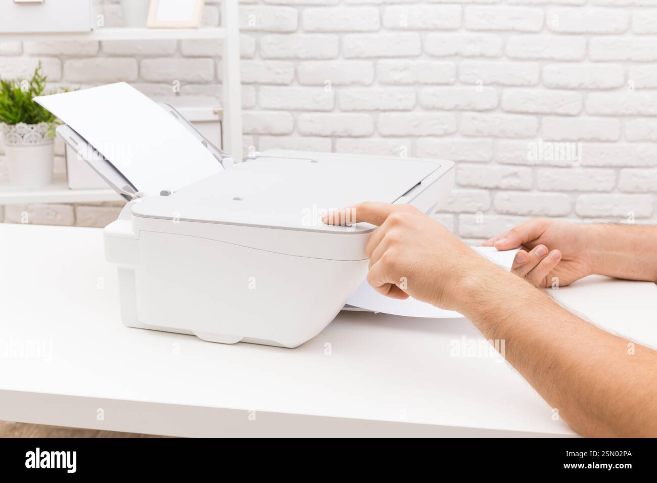 Using a printer to print documents on a clean desk in a bright ...