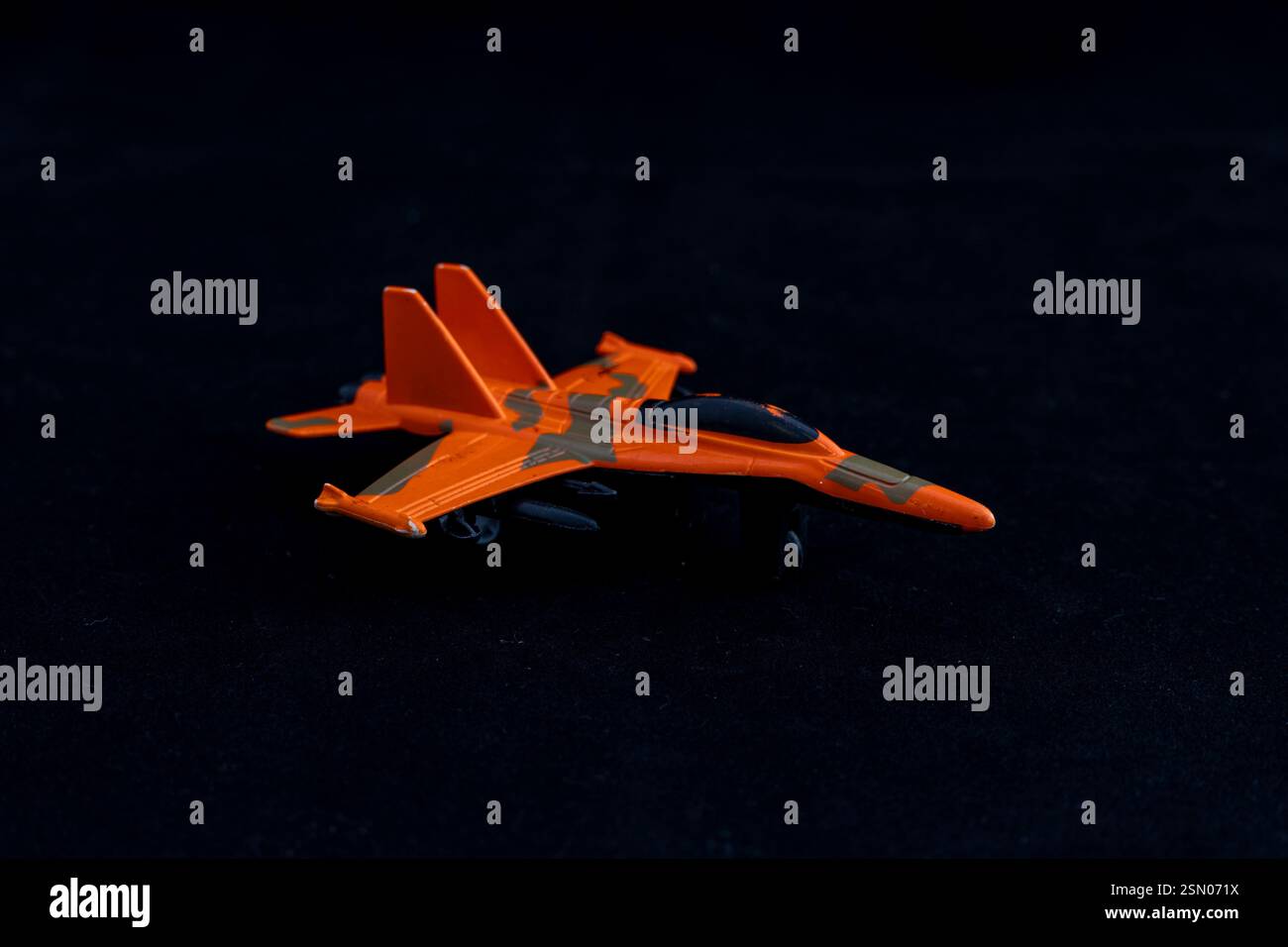 Orange Camouflage Fighter Jet Toy on Black Background Stock Photo - Alamy