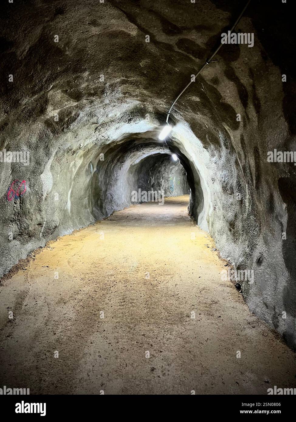 A cave with lights on top Stock Photo - Alamy