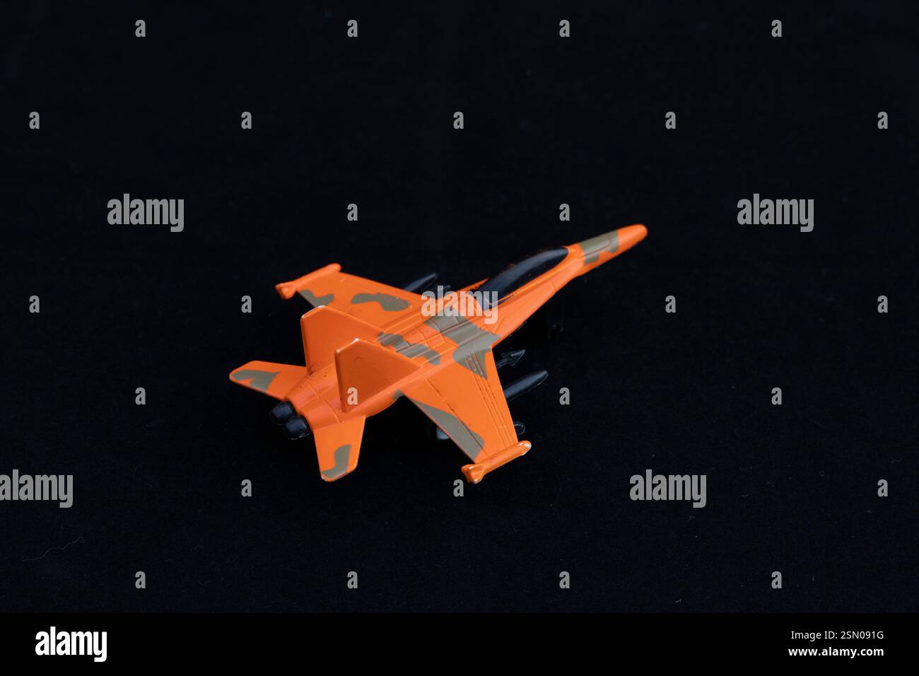 Dynamic Orange Camouflage Fighter Jet Toy on Black Background Stock ...