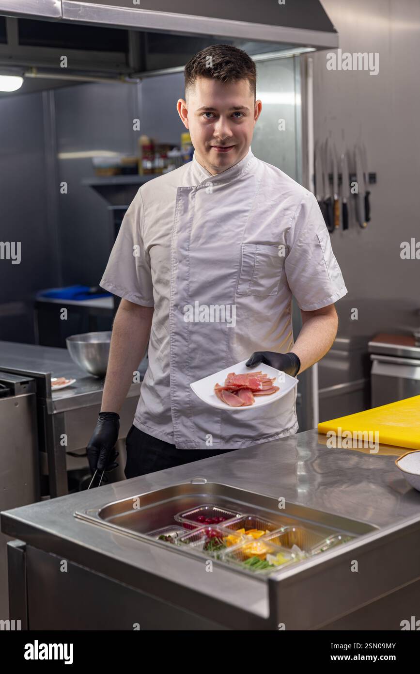 Chef in professional restaurant kitchen with tuna slices in hand Stock ...