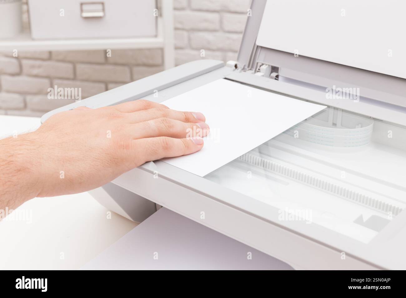 Hands placing paper in a multifunction printer for scanning in a modern ...