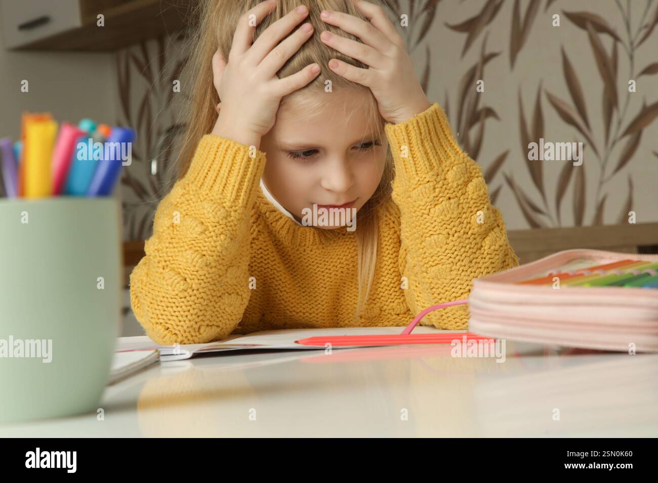 Exhausted elementary school girl is tired of doing homework, stressed ...