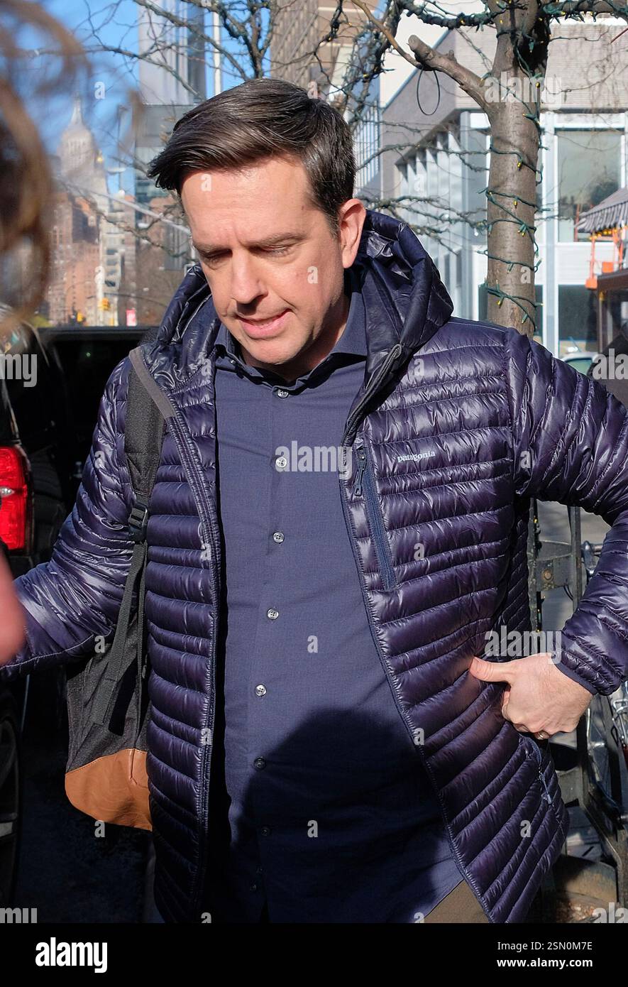 Actor Ed Helms carries a suit bag as he leaves a downtown hotel on ...