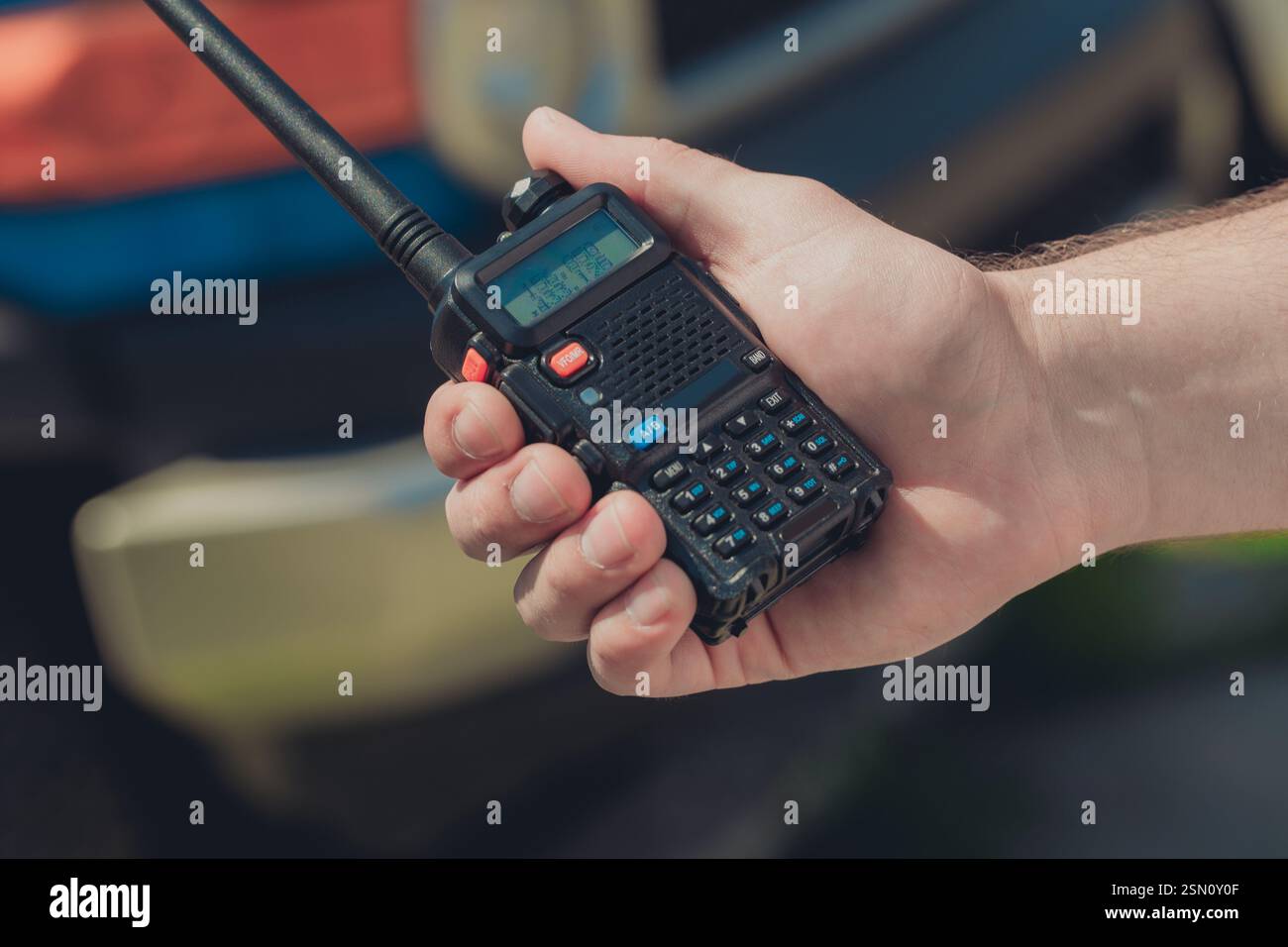 Handheld radio communication device being used outdoors during daylight ...