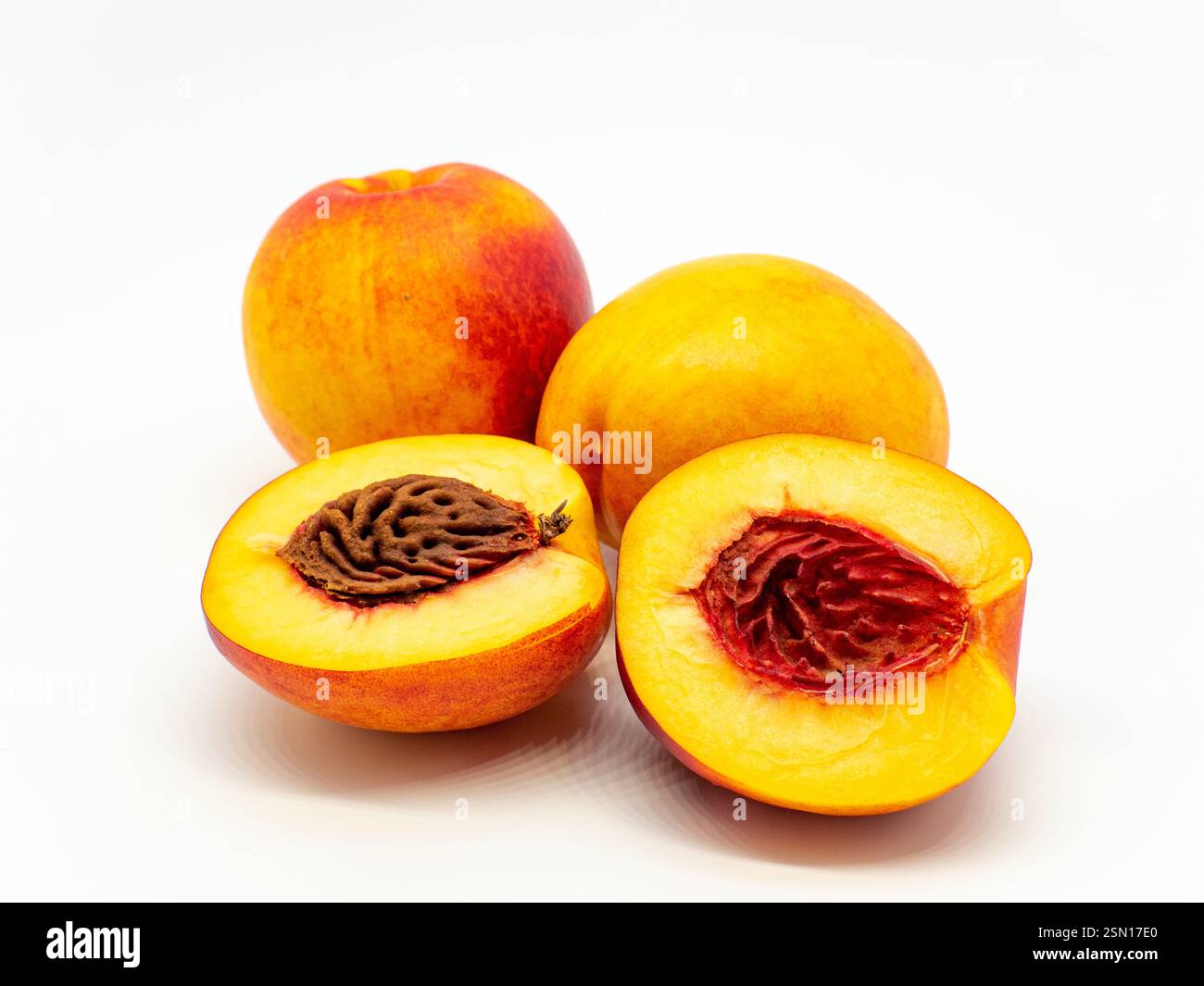 sliced and whole nectarines heap on white background Stock Photo - Alamy
