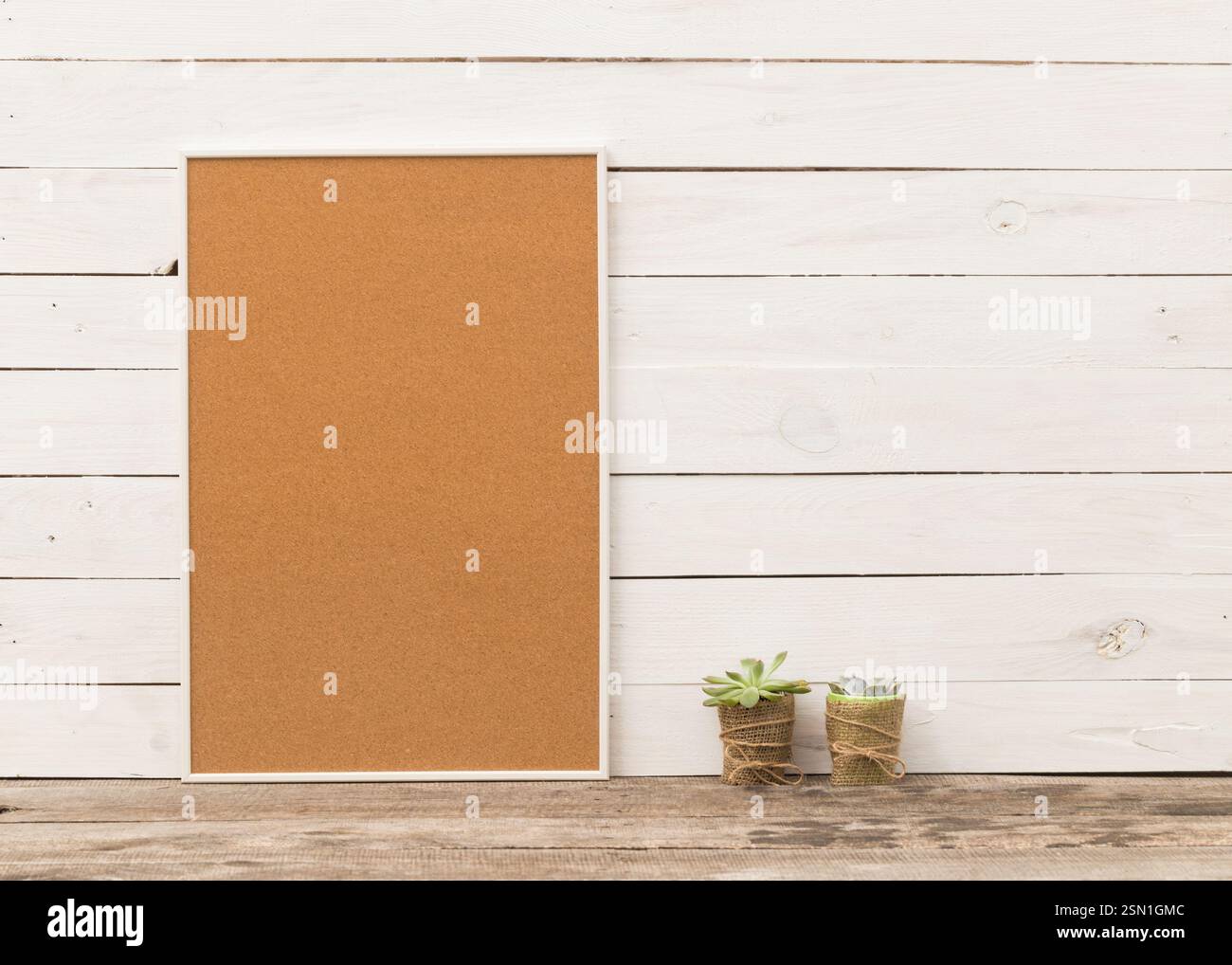 Decorative cork board and potted plants on a wooden table with white ...