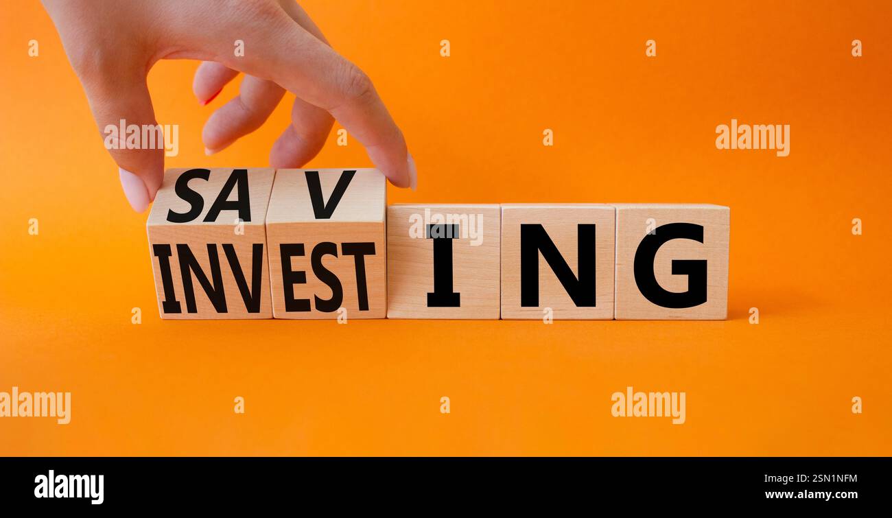 Saving and Investing symbol. Hand turns wooden cubes and changes word ...