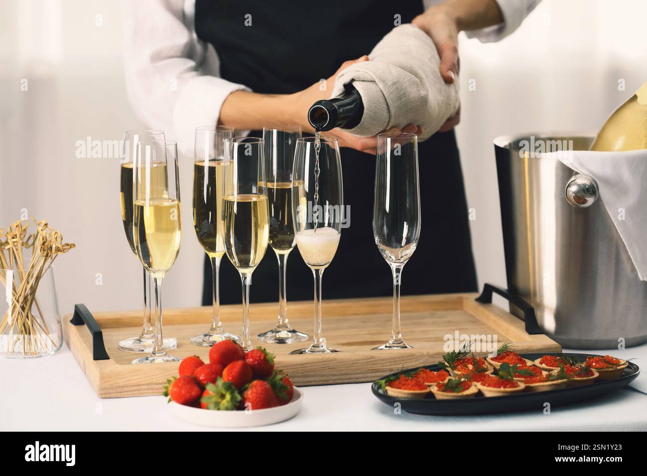 Waiter filling glasses with champagne indoors, closeup Stock Photo - Alamy