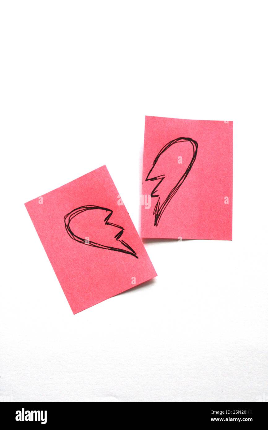 Two pieces of pink sticky note torn apart with two parts of a broken ...