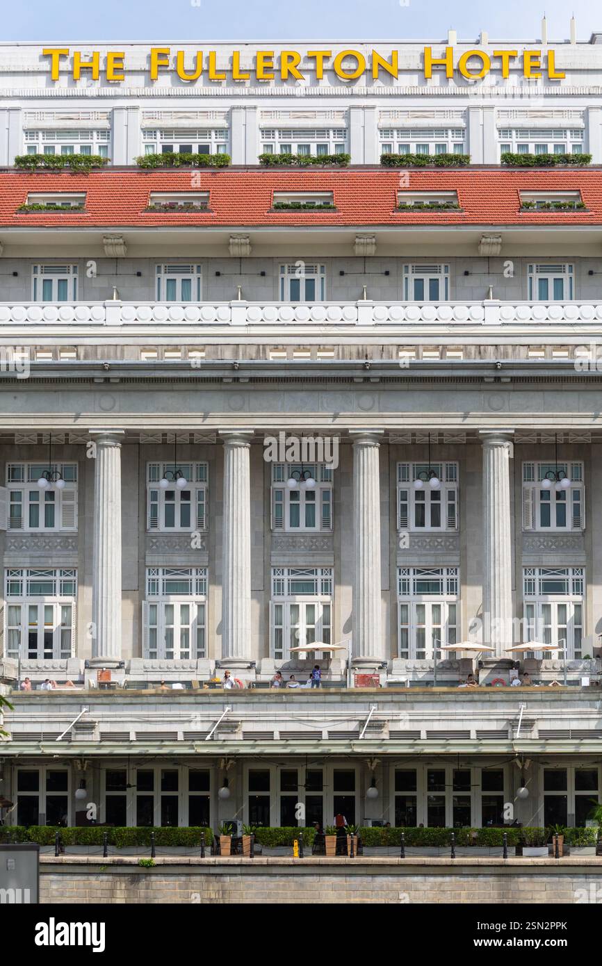 Vertical scale scene of The Fullerton Hotel, holiday guest relaxing by the swimming pool ...