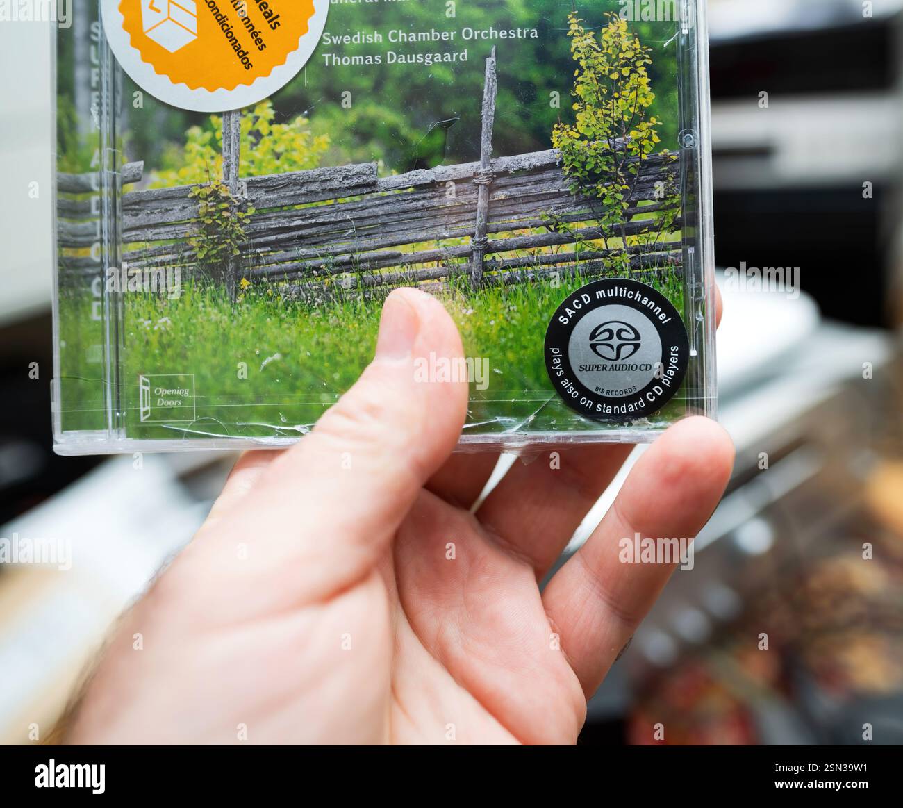 Paris, France - Mar, 8, 2023: A hand holding a cracked SACD case ...