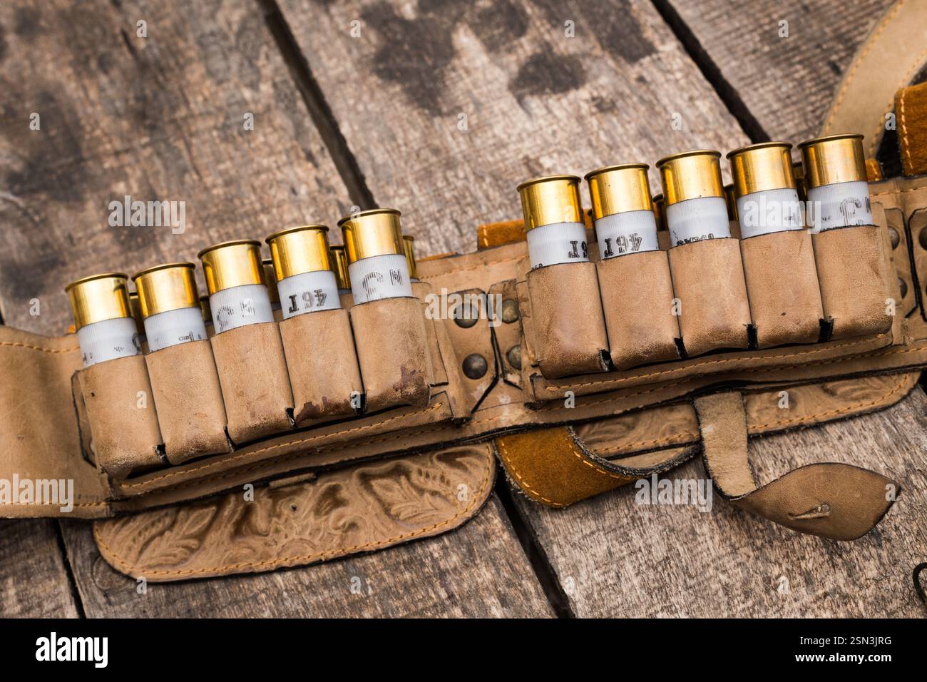 Vintage shotgun shell belt displayed against rustic wooden background ...