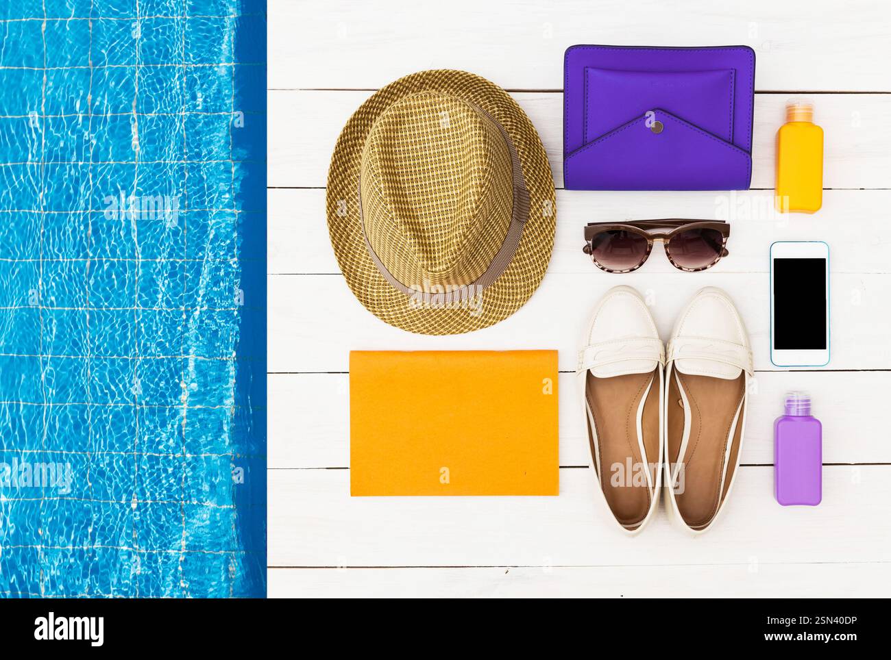 Accessories spread out by a pool with summer essentials for a relaxing ...