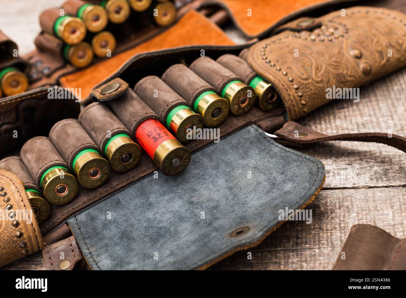 Leather cartridge belt filled with shotgun shells and rustic wooden ...
