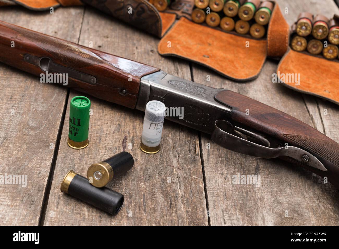 Vintage shotgun with shells displayed on rustic wooden surface in ...