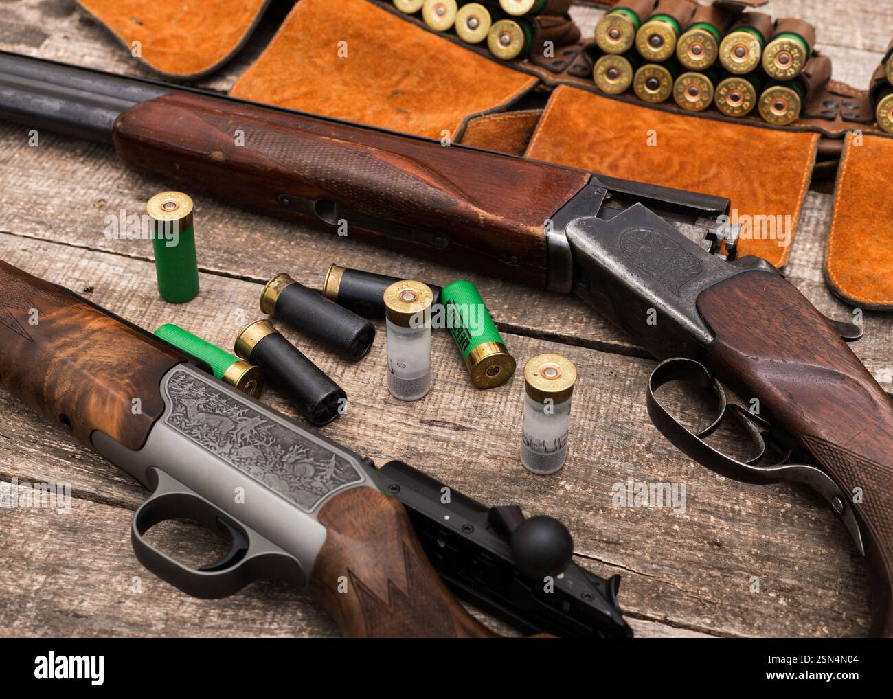 Collection of hunting shotguns and ammunition on wooden table for ...