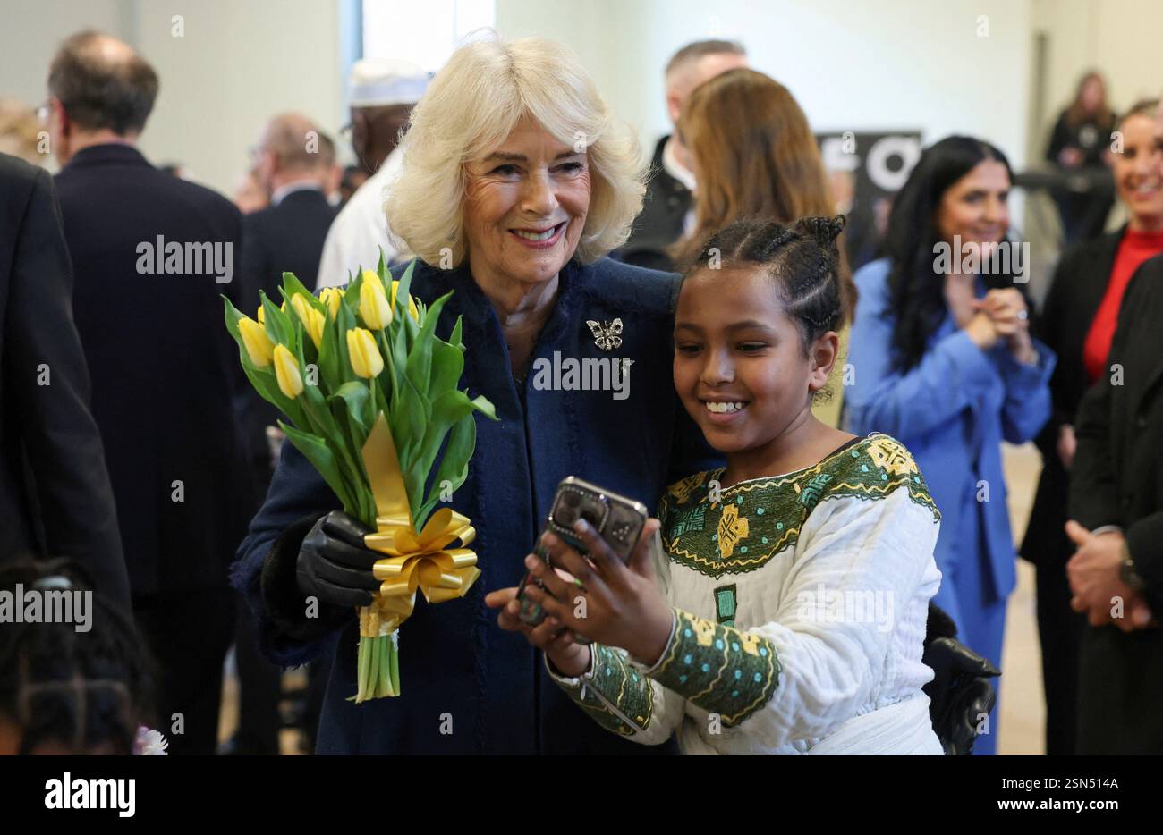 Britain's Queen Camilla poses for a selfie with a child, during a visit ...