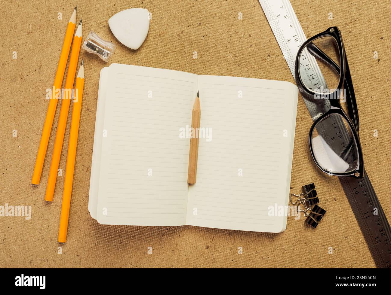 Writing tools and materials arranged on a workspace with a blank ...