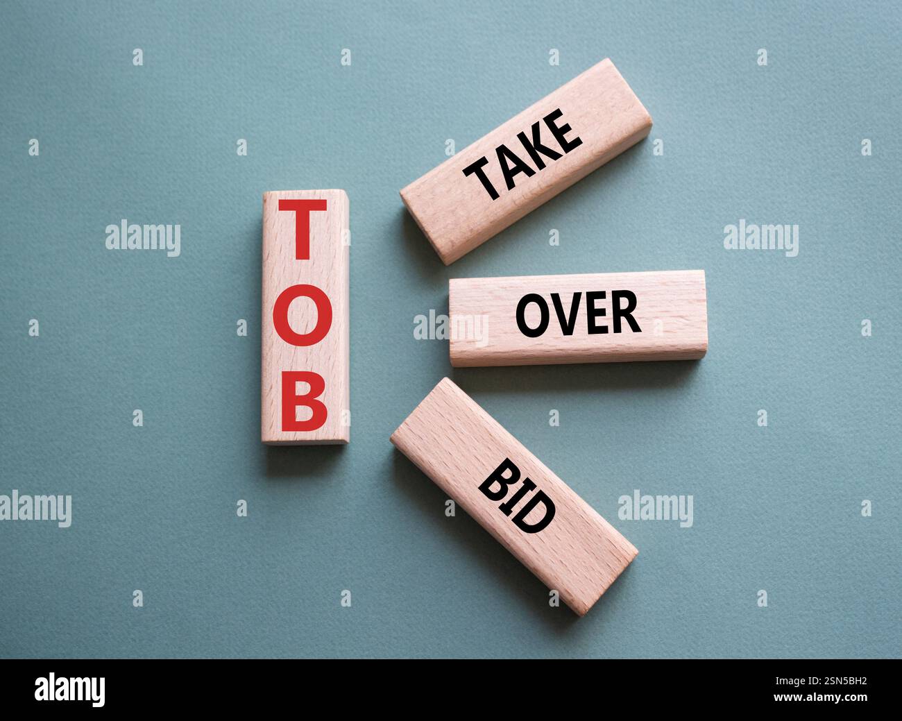 TOB - Take Over Bid. Wooden cubes with words TOB. Beautiful grey green ...
