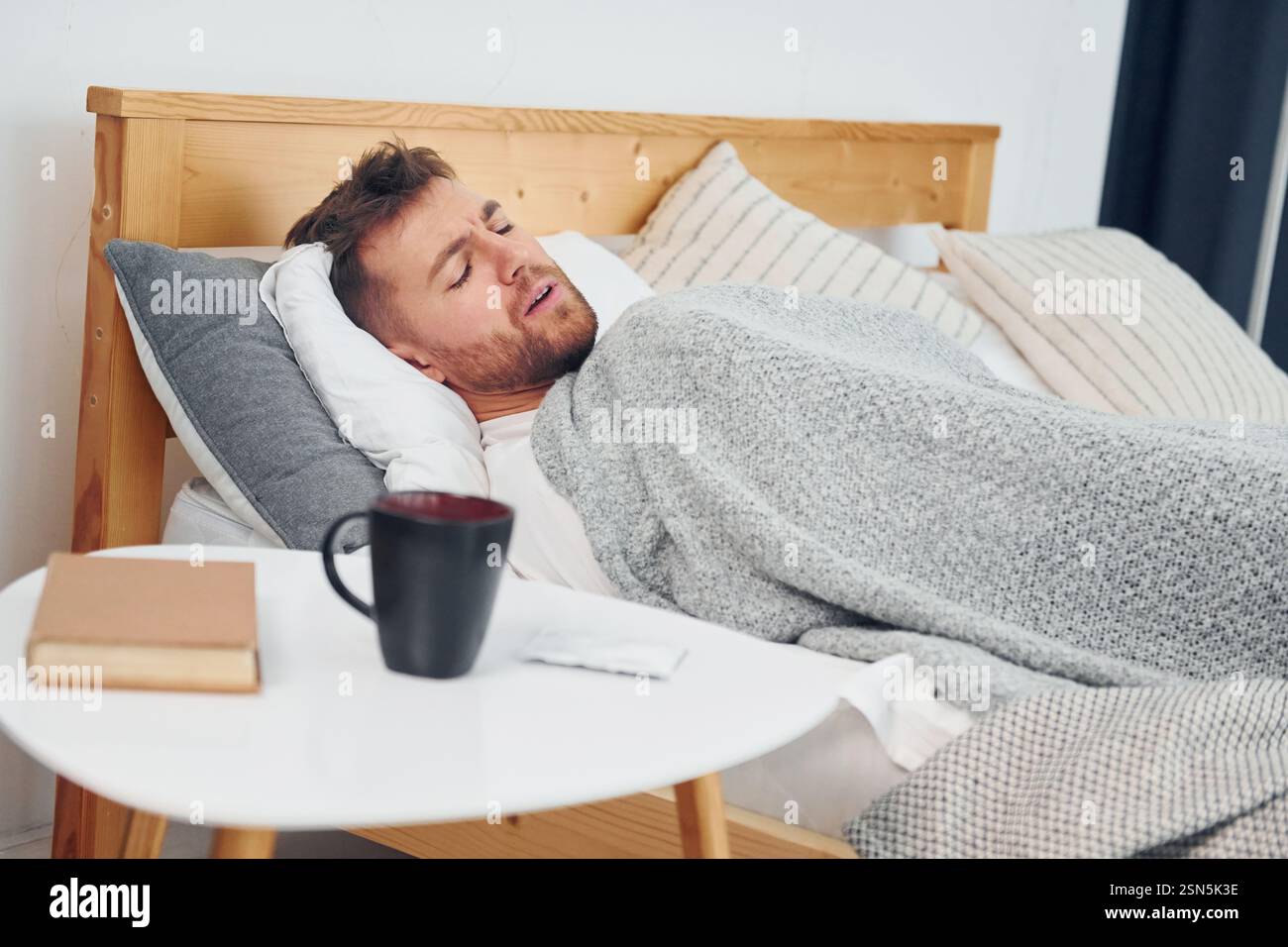 Sick man laying down on the bed at home and feels bad. Conception of ...