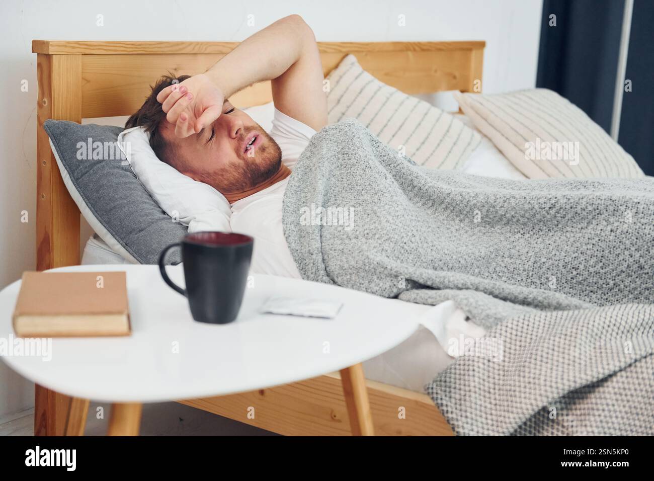 Sick man laying down on the bed at home and feels bad. Conception of ...