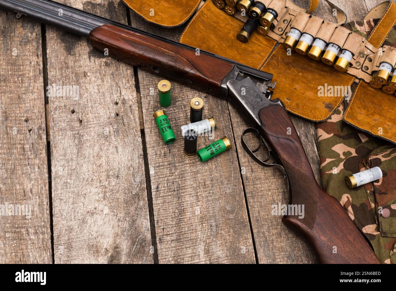 Classic shotgun and ammunition displayed on rustic wooden surface with ...
