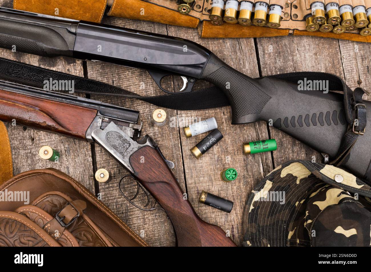 Collection of shotguns and ammunition displayed on a rustic wooden ...