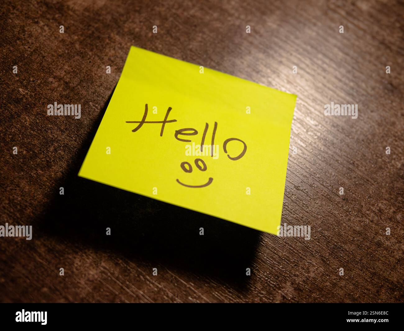 Bright yellow sticky note displays a cheerful hello and a smiley face ...