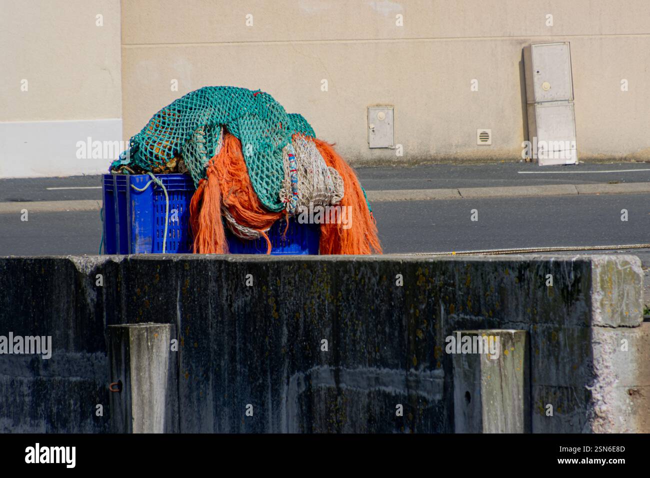 A collection of brightly colored fishing nets and gear stacked on a ...