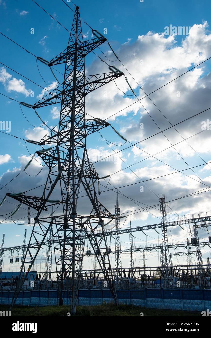A large electrical power substation with towering transmission lines ...