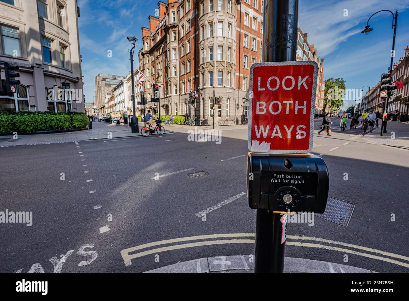 A traffic light with a push button for pedestrians to cross the street ...