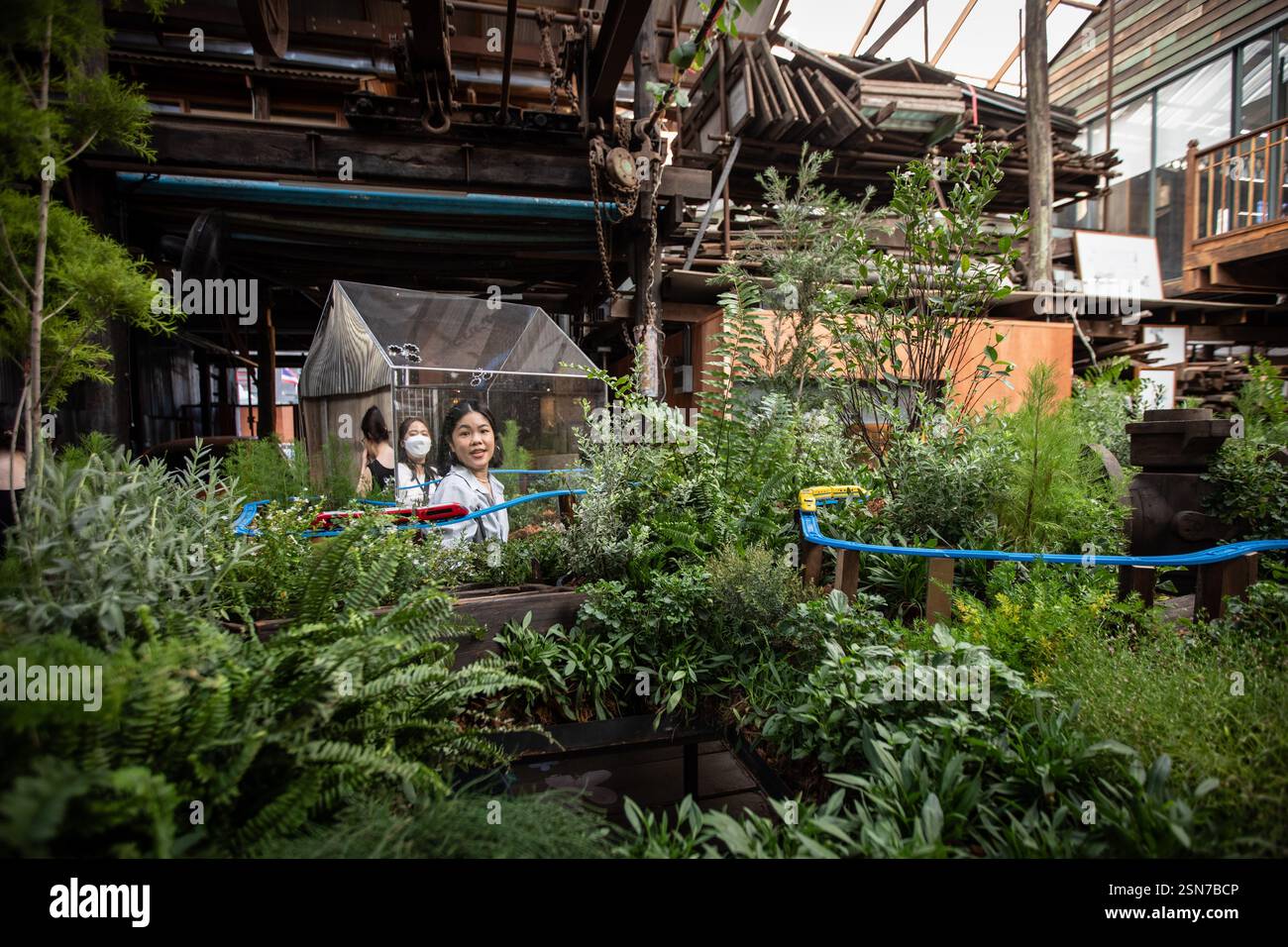Bangkok. 13/02/2025, A woman looks at the art installation through a ...