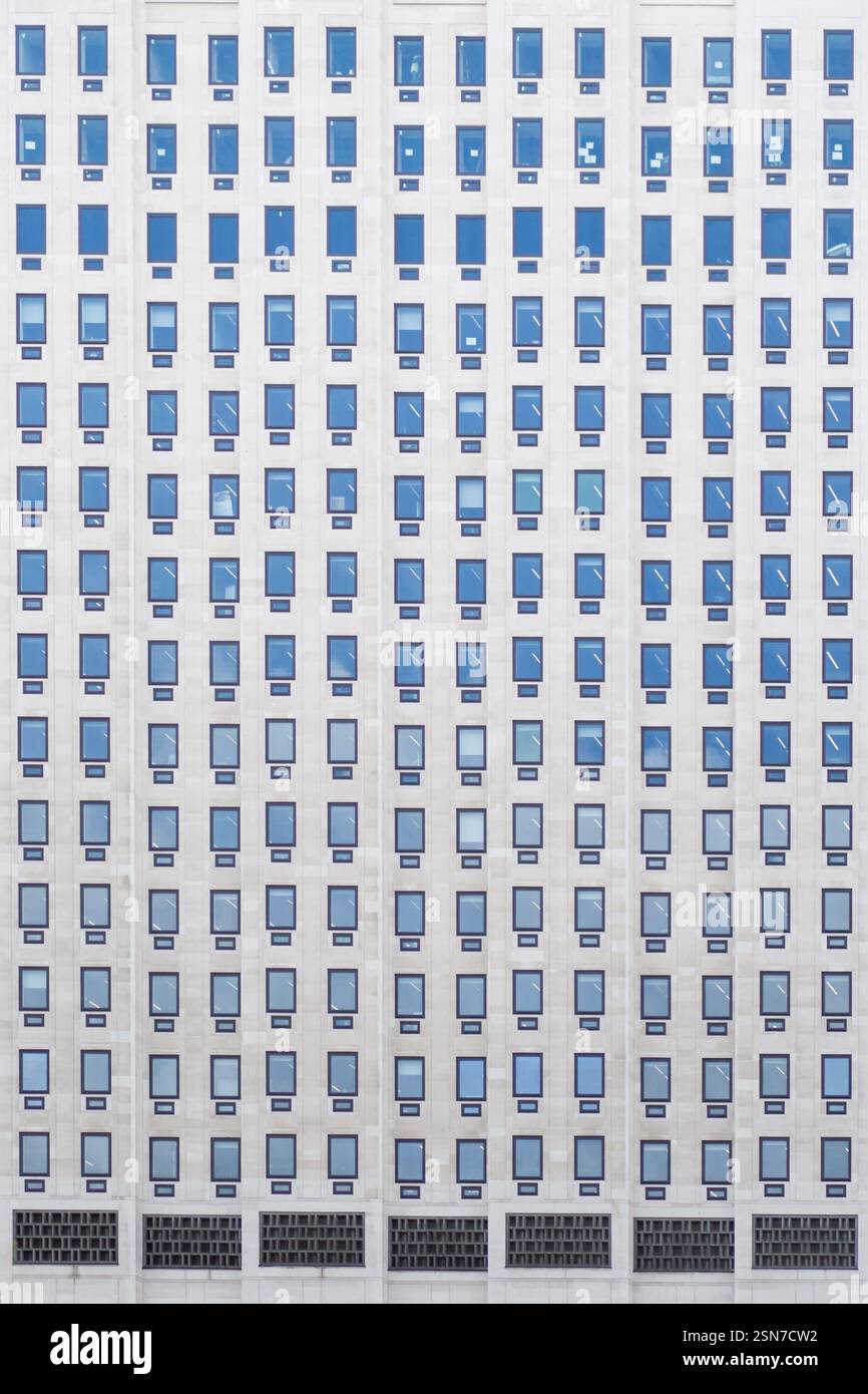 Symmetrical building facade showcases rows of blue tinted windows ...