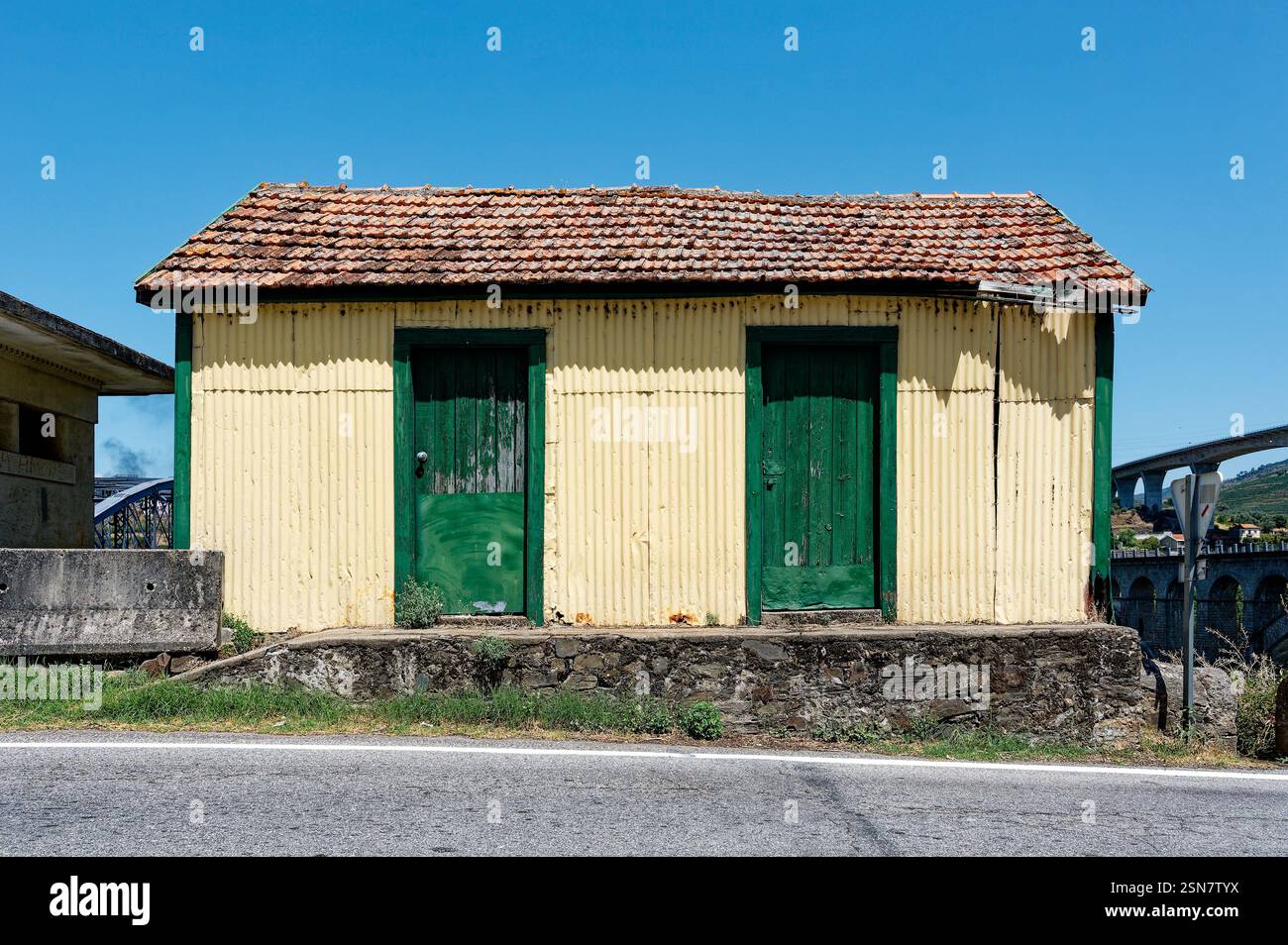 A small, weathered building with a corrugated metal facade and faded ...