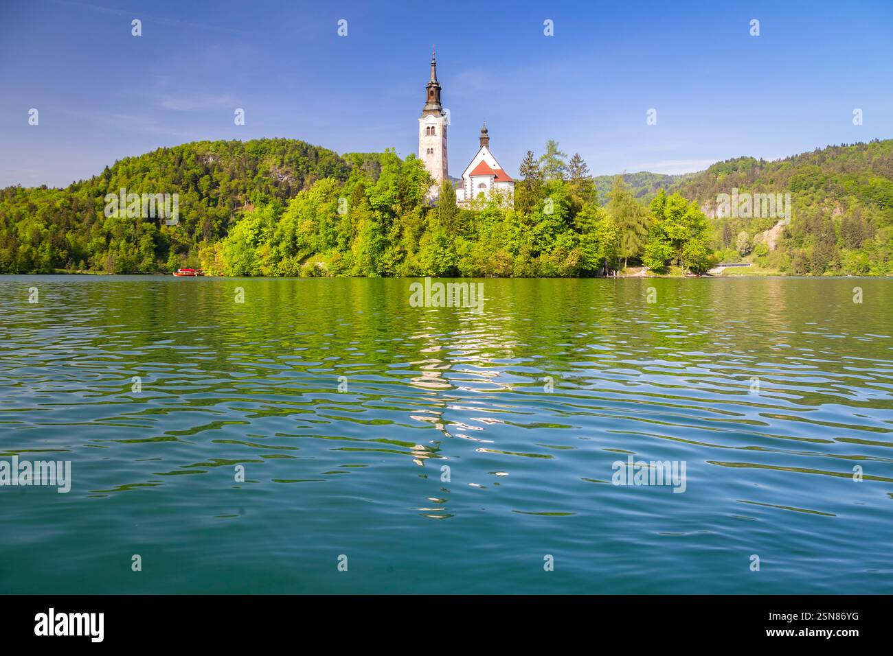 View of lake Bled at in spring with the small island and Assumption of ...
