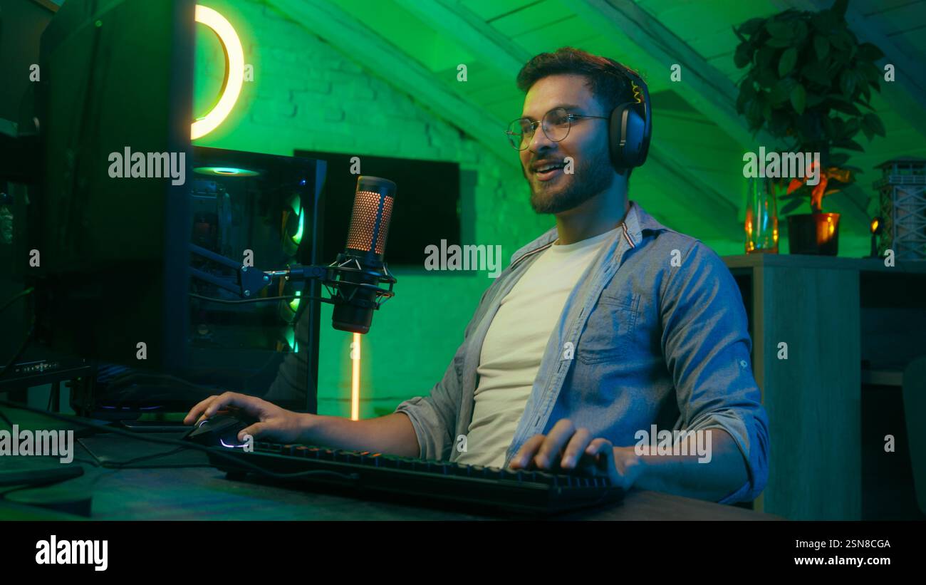 Emotional smiling streamer in headphones play video game Caucasian man ...