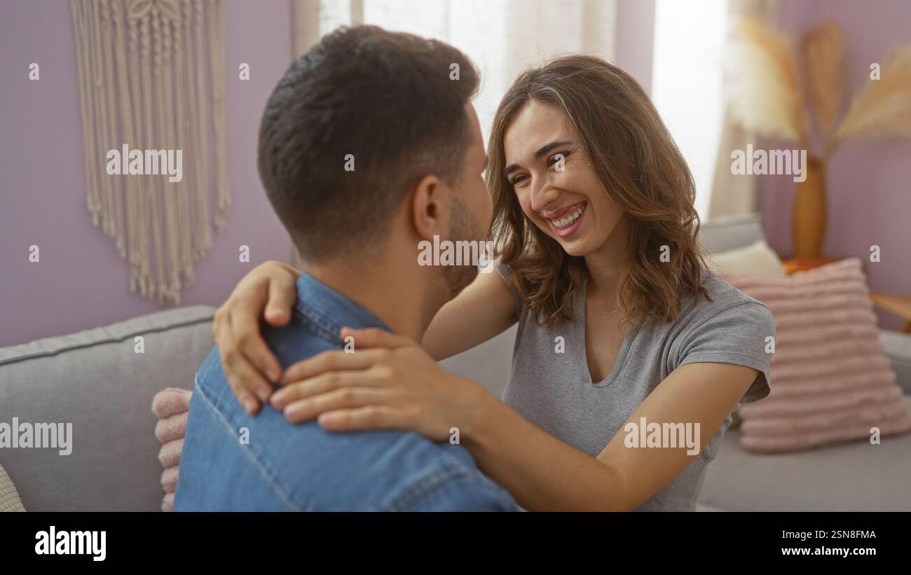 Couple smiling together on sofa in cozy apartment room creating ...