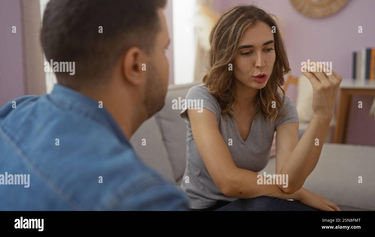 Woman talking with man in living room, discussing important topics at ...