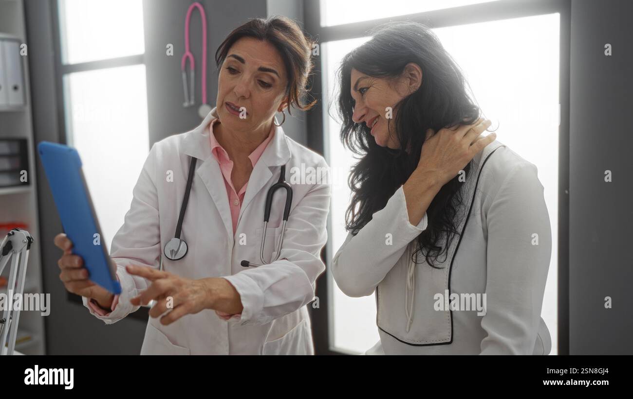 Female doctor shows digital tablet to smiling patient in a bright ...
