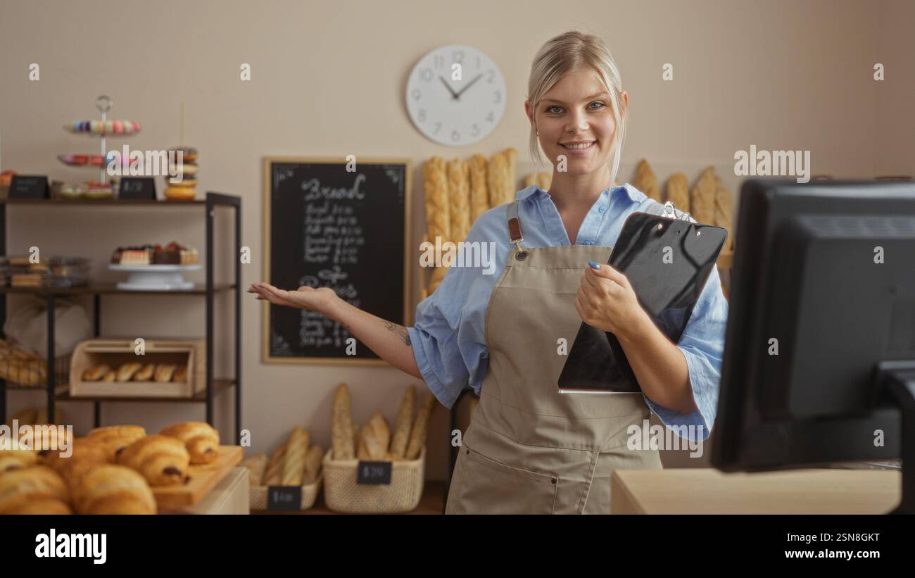 Young, attractive, blonde, woman, standing in a bakery shop, presenting ...