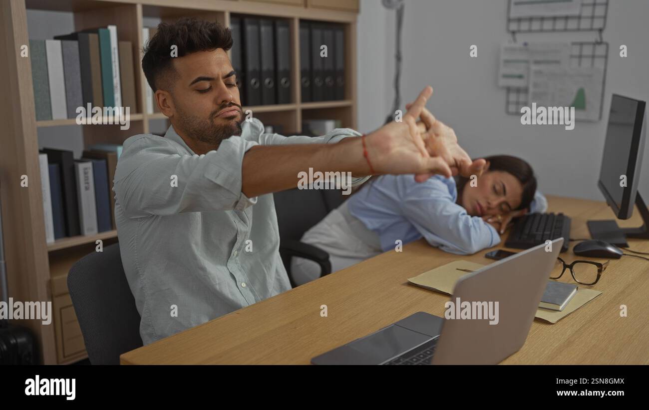 Man stretching and woman sleeping at their desks in an office ...