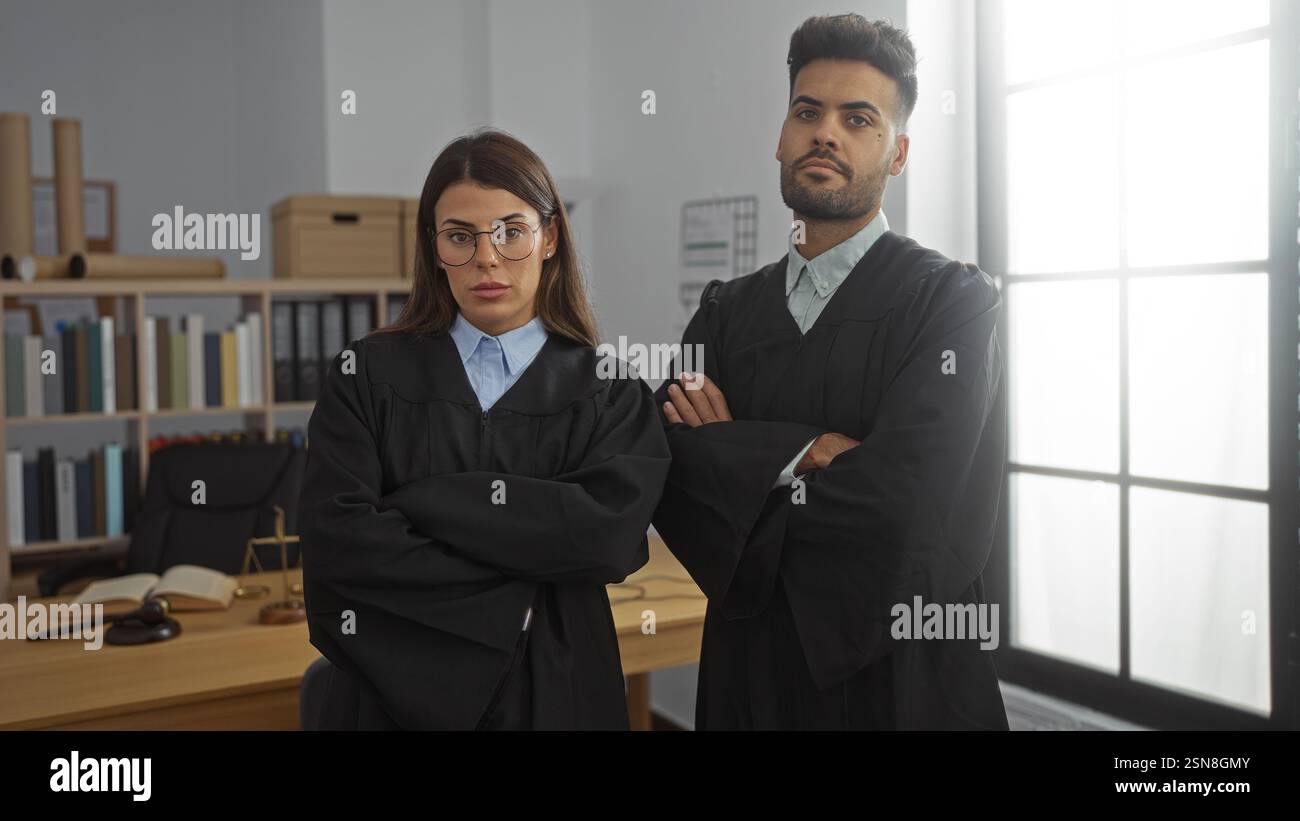 Woman and man standing together in an office with arms crossed, wearing ...
