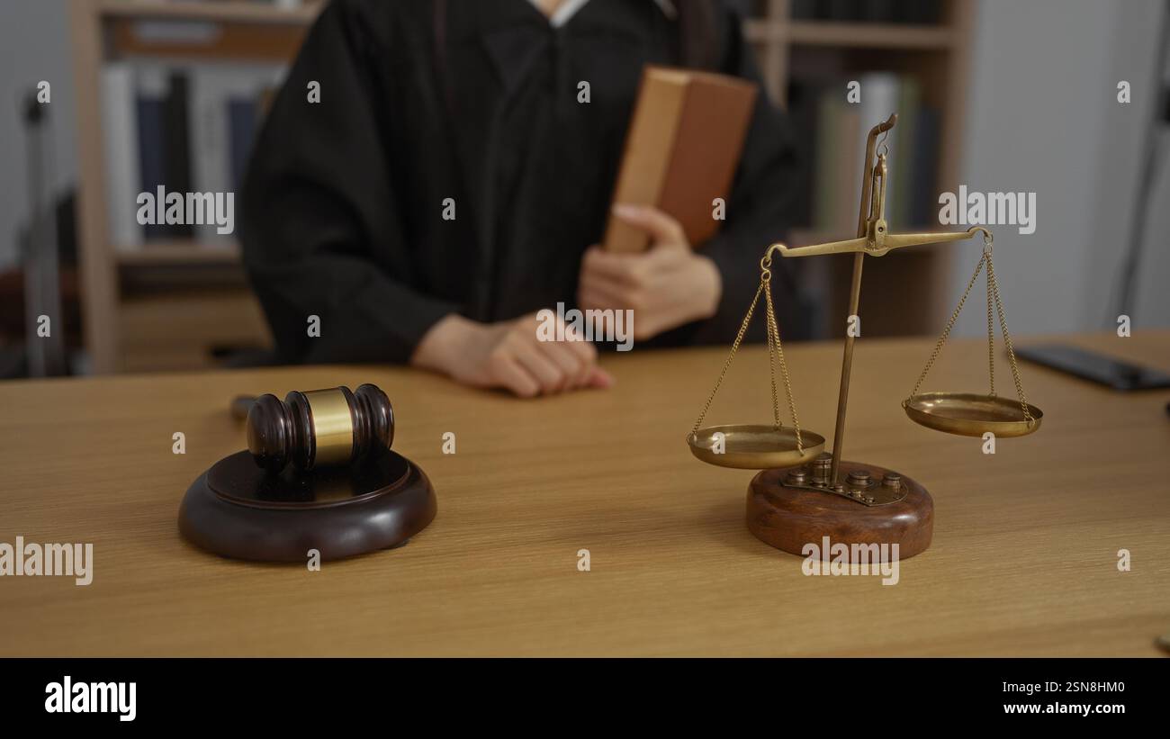 Woman judge indoors holding a book with scales of justice and gavel on ...