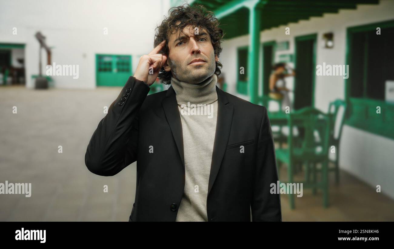 Man posing confidently outdoors on a city street, wearing a black suit ...
