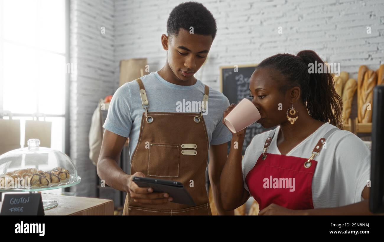 Bakers working together in a bakery room, with a man holding a tablet ...