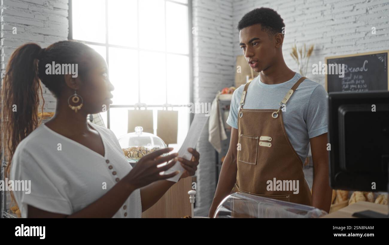 Woman holding ticket talking to baker in apron inside a bakery shop ...