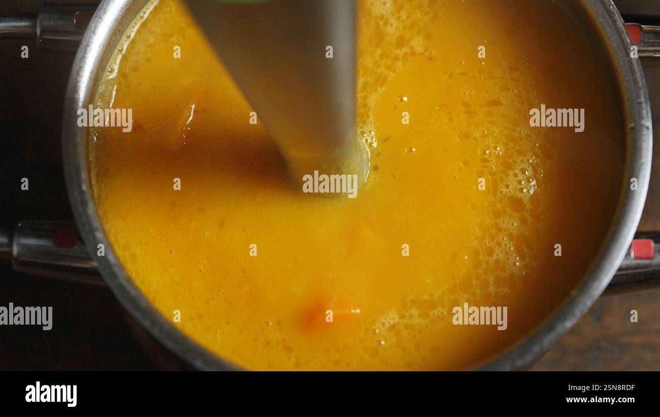 Cooking pumpkin soup. Blending with a blender Stock Photo - Alamy