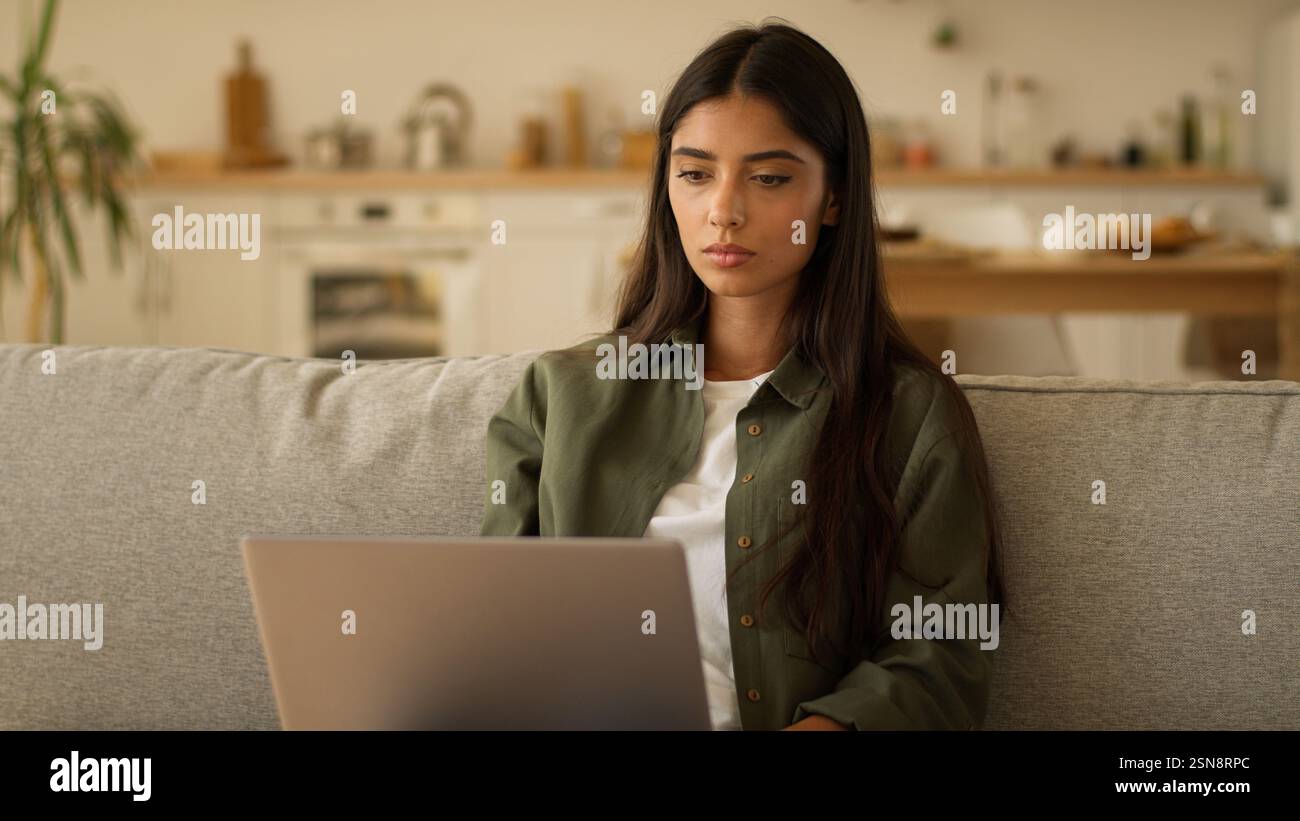 Concentrated Arabian woman Indian freelancer girl student female Hispanic lady at home couch ...
